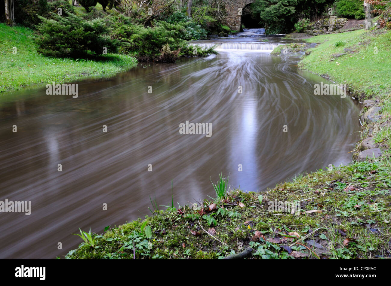 River flowing under bridge and over weir Stock Photo - Alamy