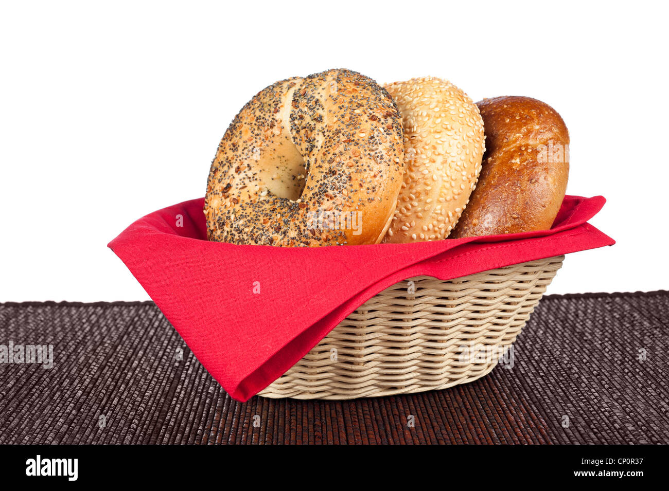 A wicker basket with three bagels including an onion bagel, sesame seed ...