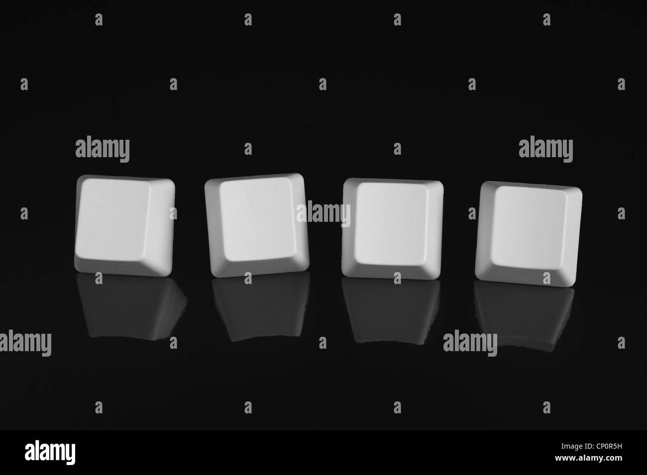 A set of four blank computer keyboard keys on a black surface Stock ...