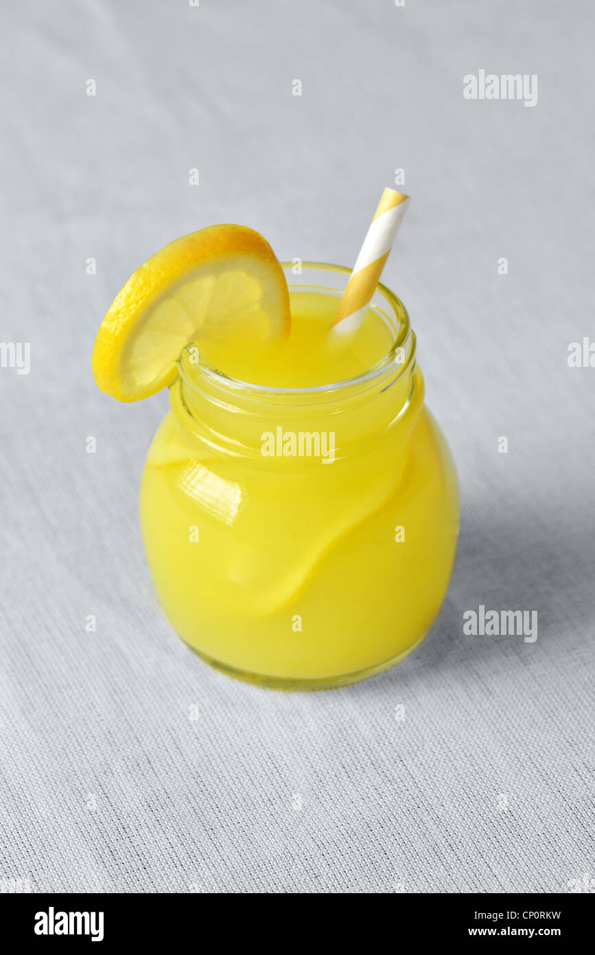 Lemonade in a Mason Jar with yellow striped straw and lemon wedge Stock ...
