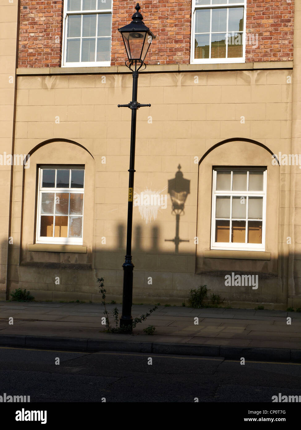 Old style streetlight with shadow on Victorian building Stock Photo - Alamy