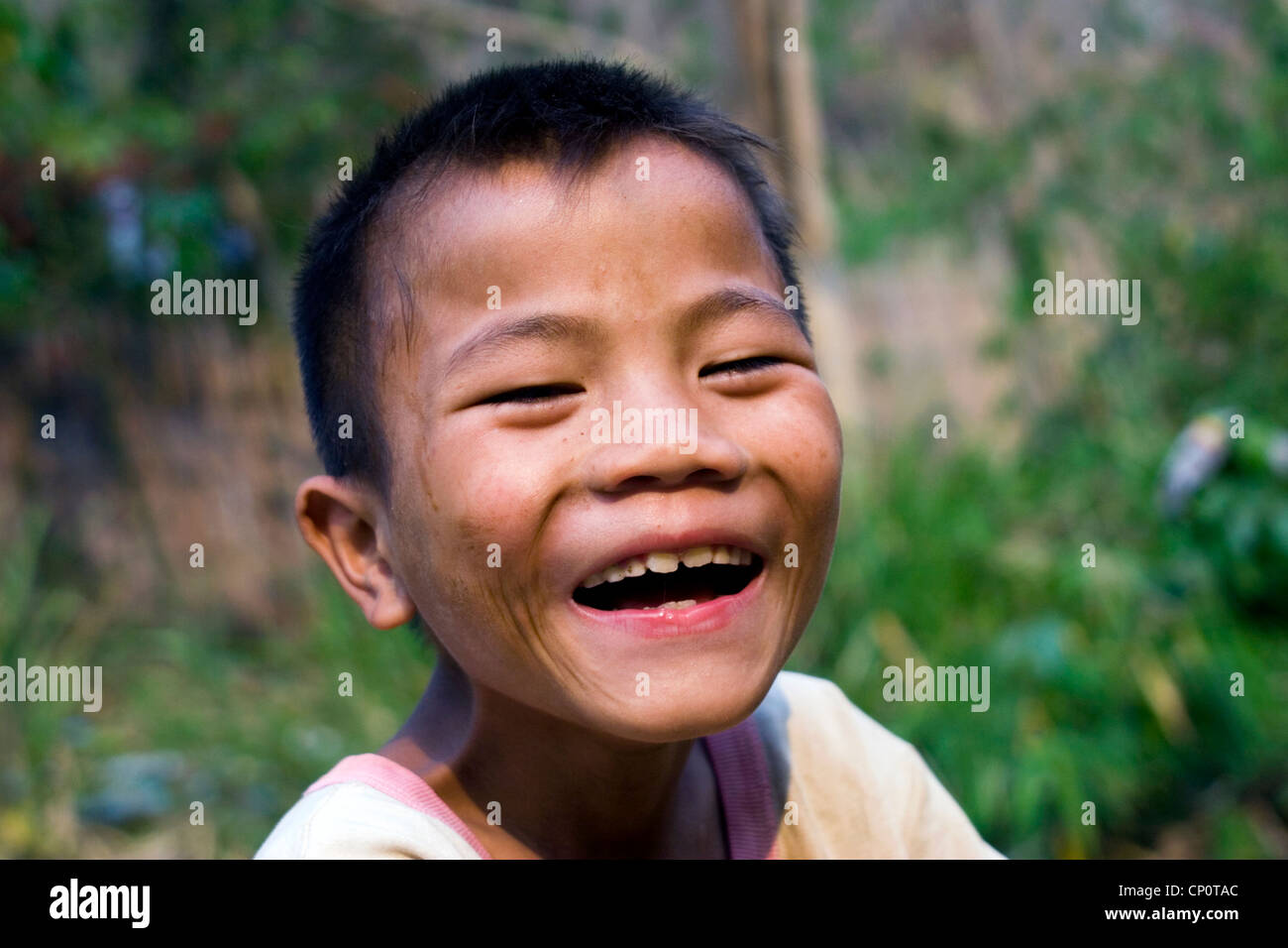 A young Thai boy is smiling in rural Pang Ma Pha, (Sappong) Thailand ...