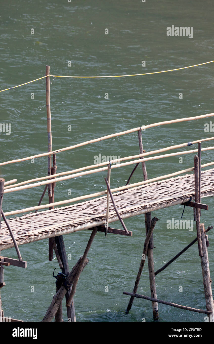 A flimsy bamboo footbridge thrown across the Khan river, a tributary of ...