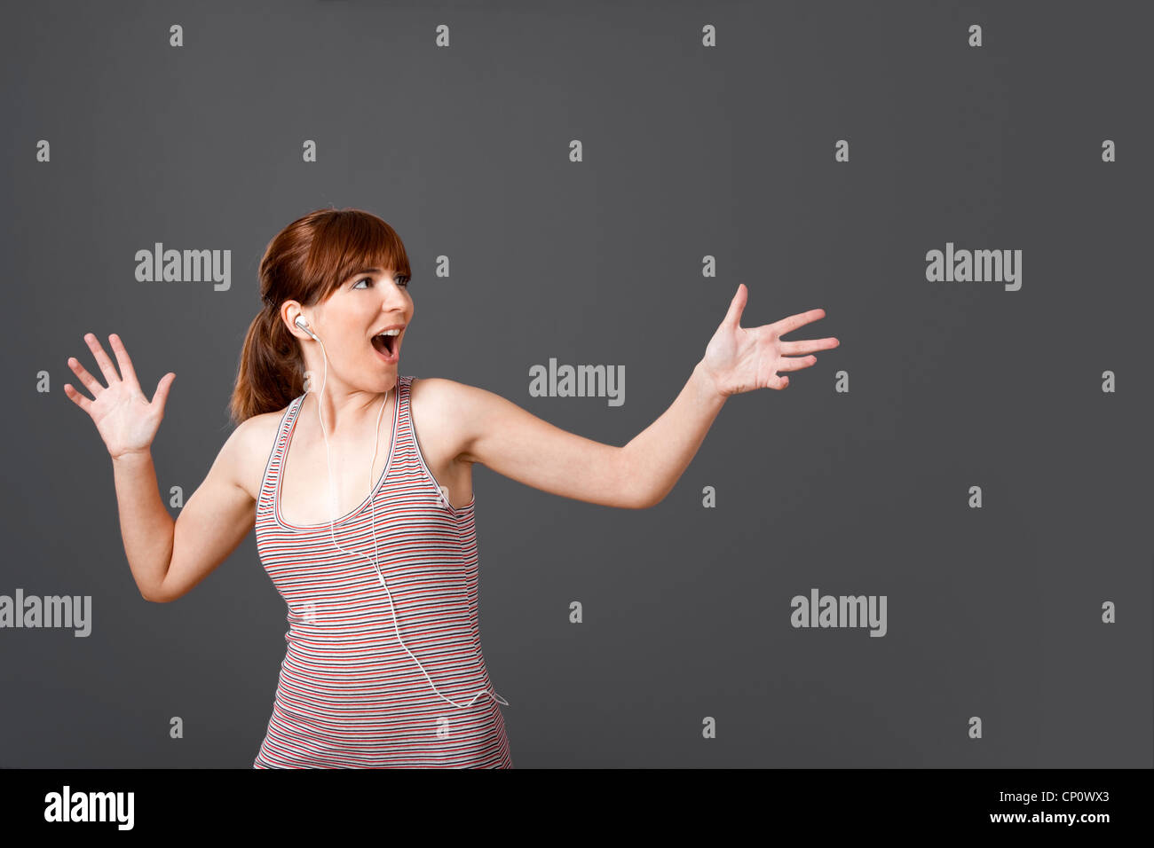 Happy young woman dancing and singing while listen music Stock Photo ...
