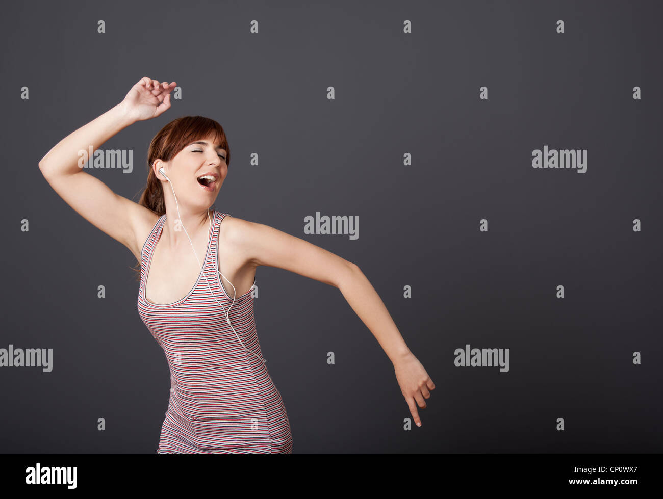 Happy young woman dancing and singing while listen music Stock Photo ...
