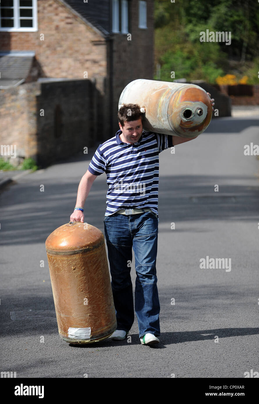 Man carrying copper water tanks for scrap Stock Photo - Alamy