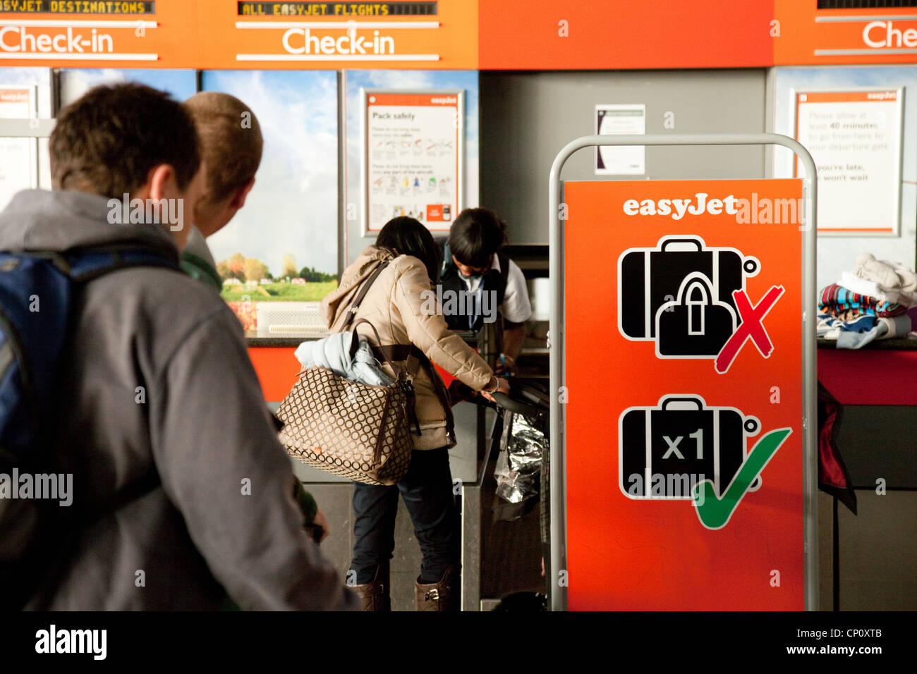 People queue at the Easyjet Check-In, Stansted airport terminal, Essex ...