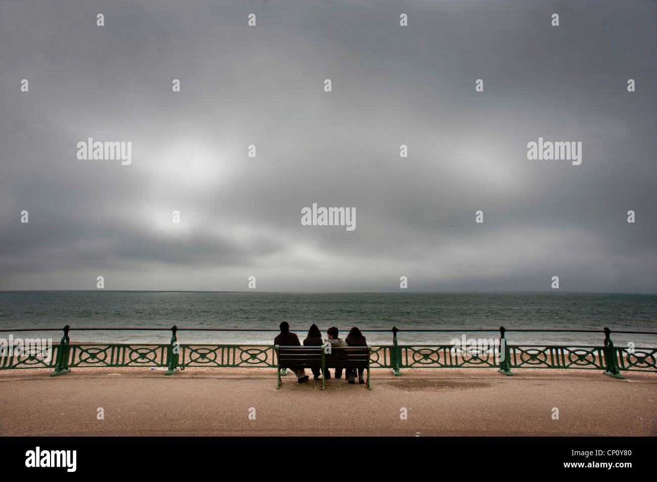 Four people sitting on a bench on Hove seafront Stock Photo - Alamy