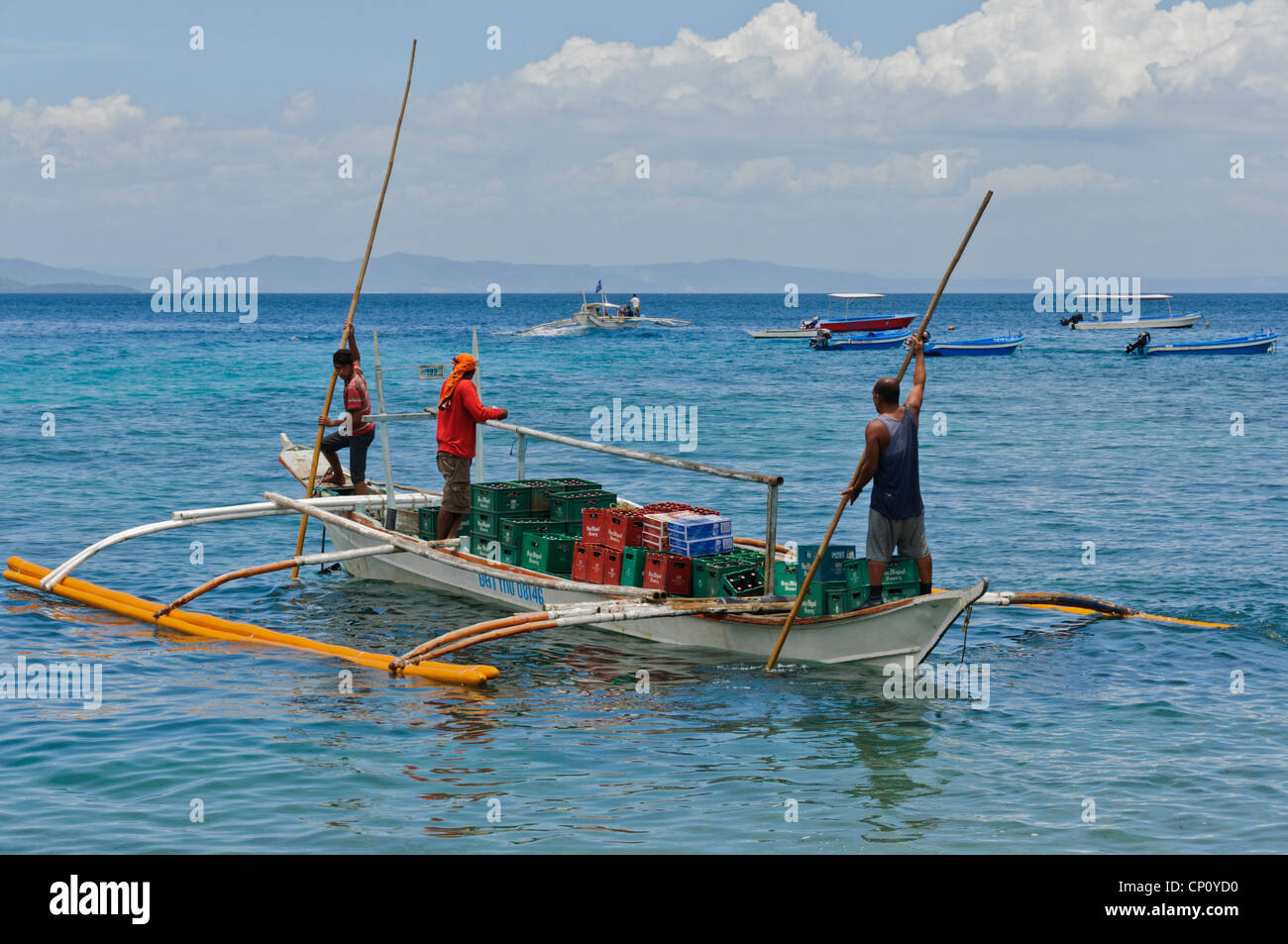 Outrigger boat transporting San Miguel Brewery beer crates over ocean ...
