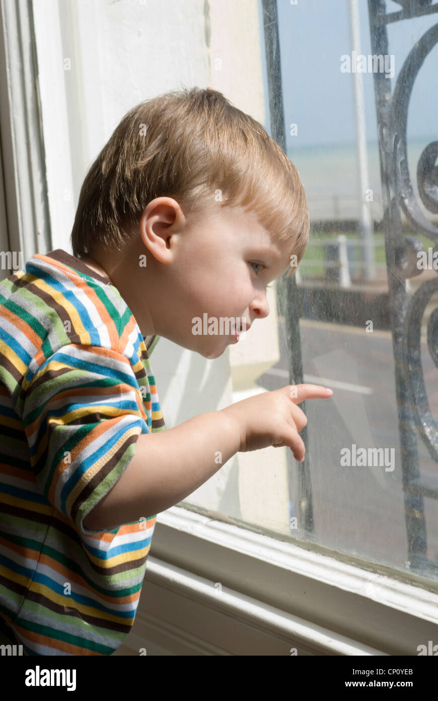 Boy pointing out window hi-res stock photography and images - Alamy