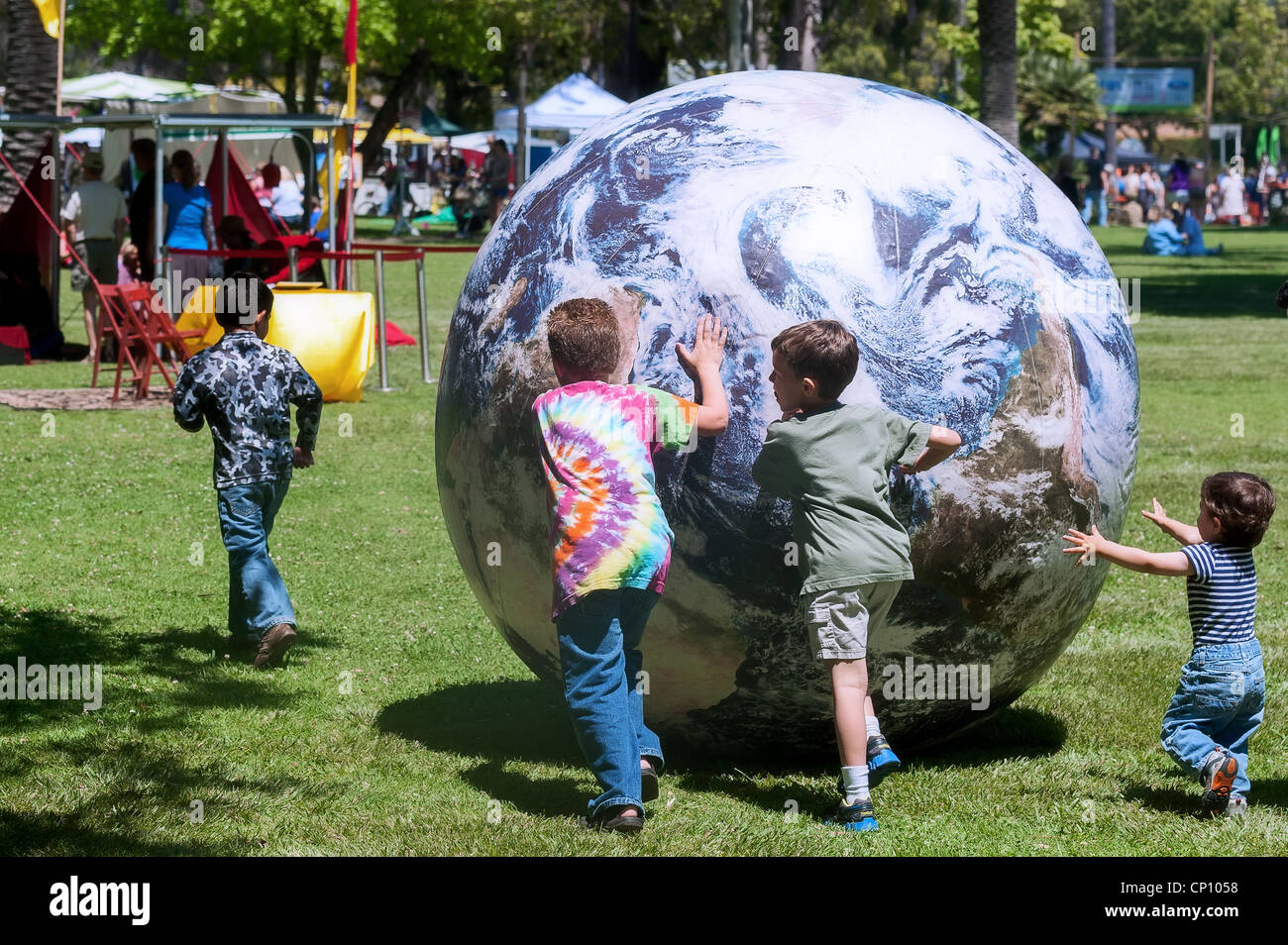 Children roll a giant "planet Earth" inflatable ball at the annual ...