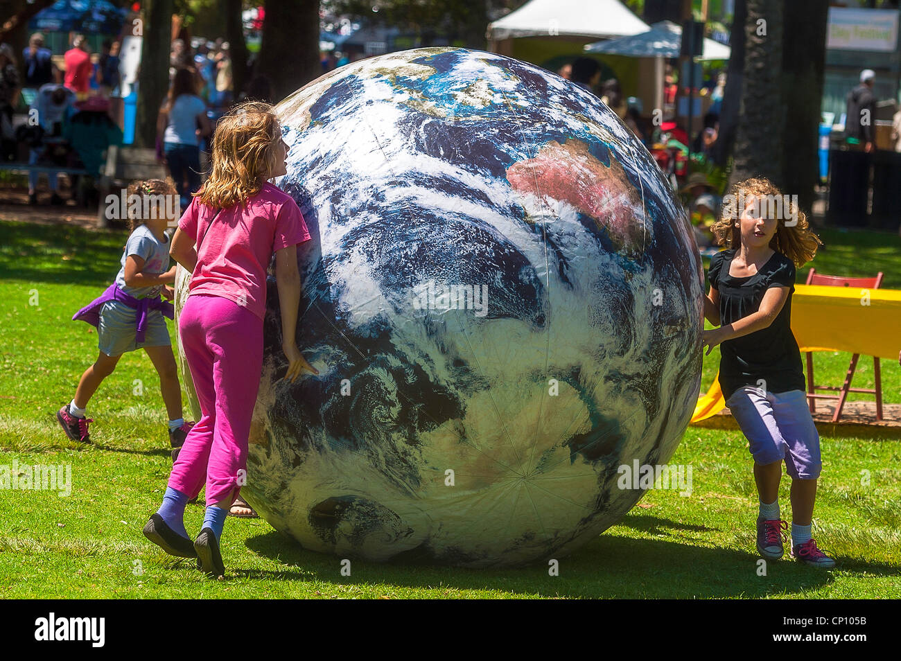 Children roll a giant "planet Earth" inflatable ball at the annual ...