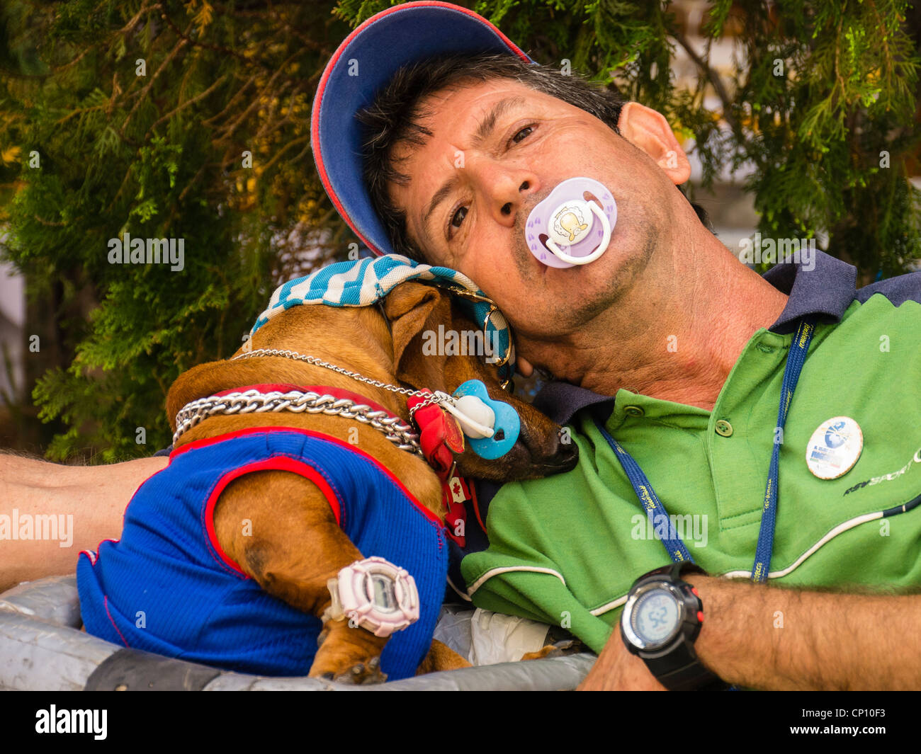 A Cuban street performer poses with one of his trained dachshund dogs ...