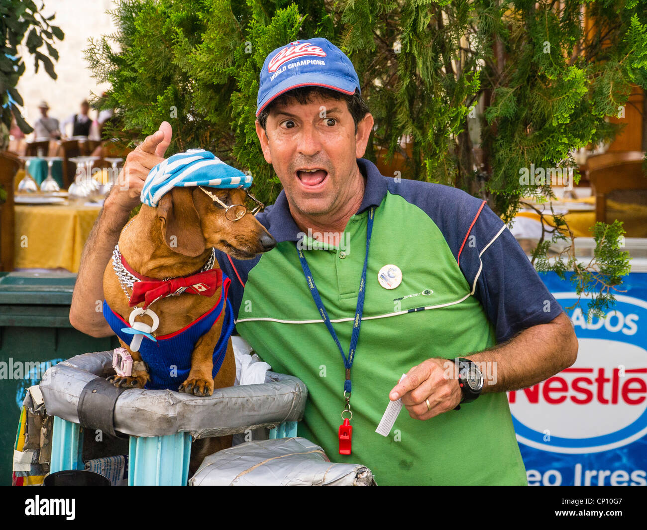 A Cuban street performer poses with one of his trained dachshund dogs ...