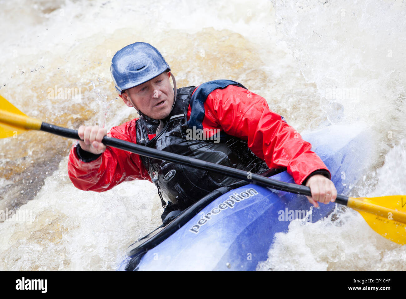 a man in a conoe, white water kayaking in bala north wales, snowdonia ...