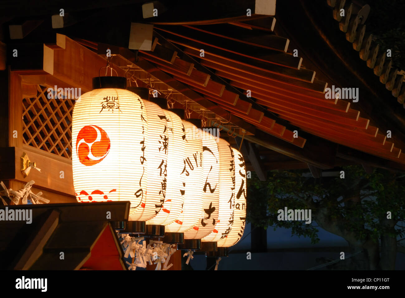 row of traditional Japanese lanterns under the wooden temple roof at ...