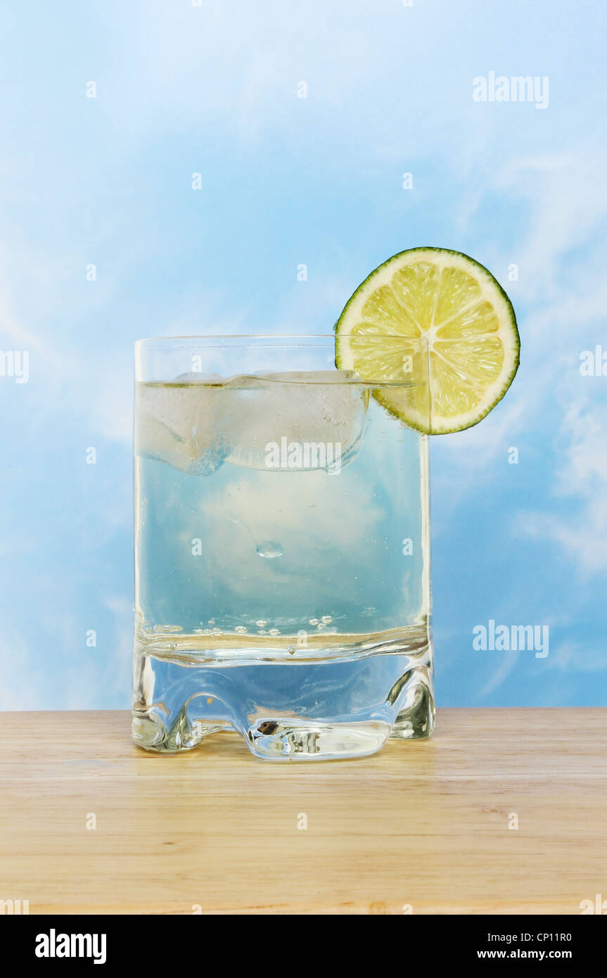 Cool and refreshing lime flavored drink on a wooden surface against a ...