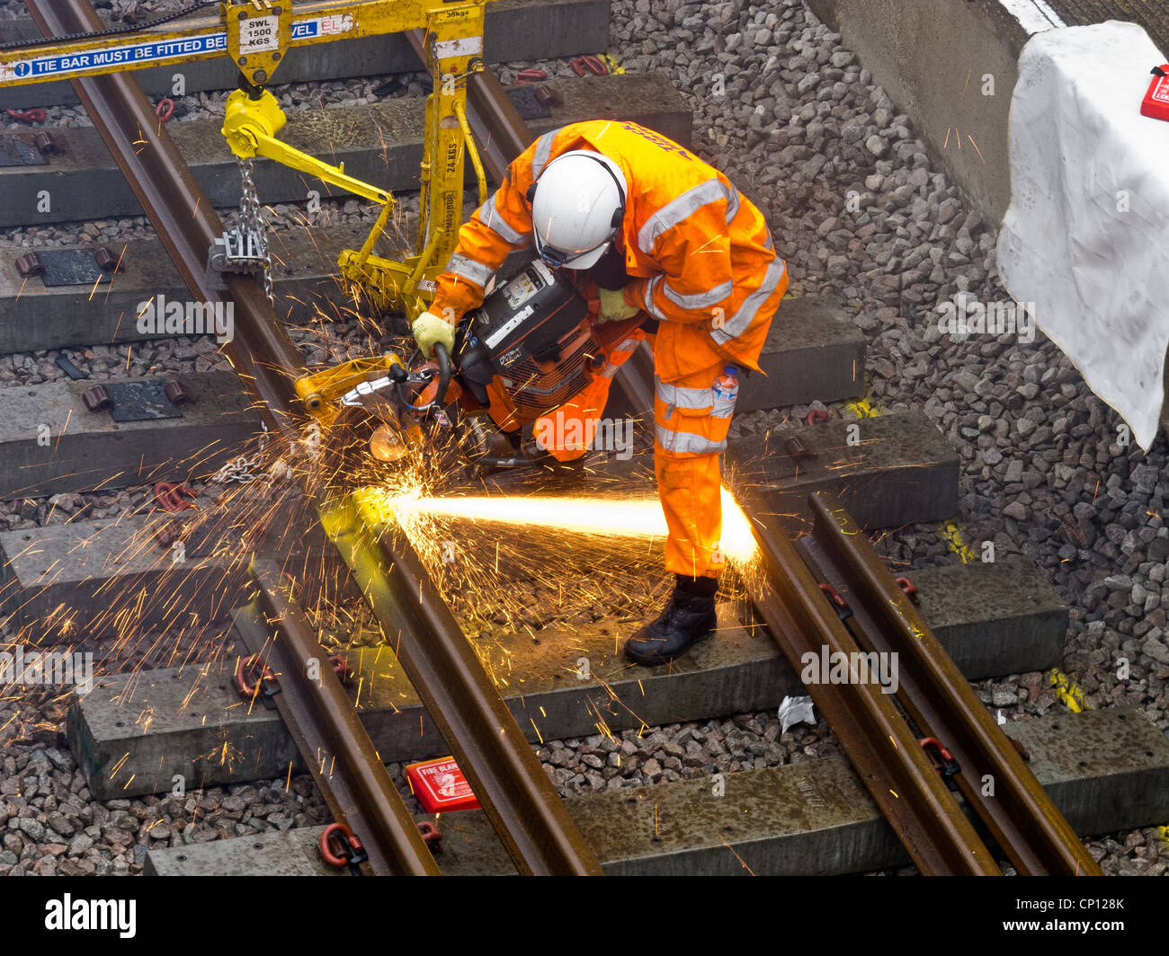 Railway worker cutting new track to correct length Stock Photo - Alamy