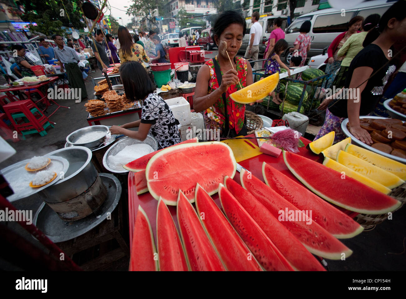 A street vendor displays slices of red and yellow watermelon in Yangon ...