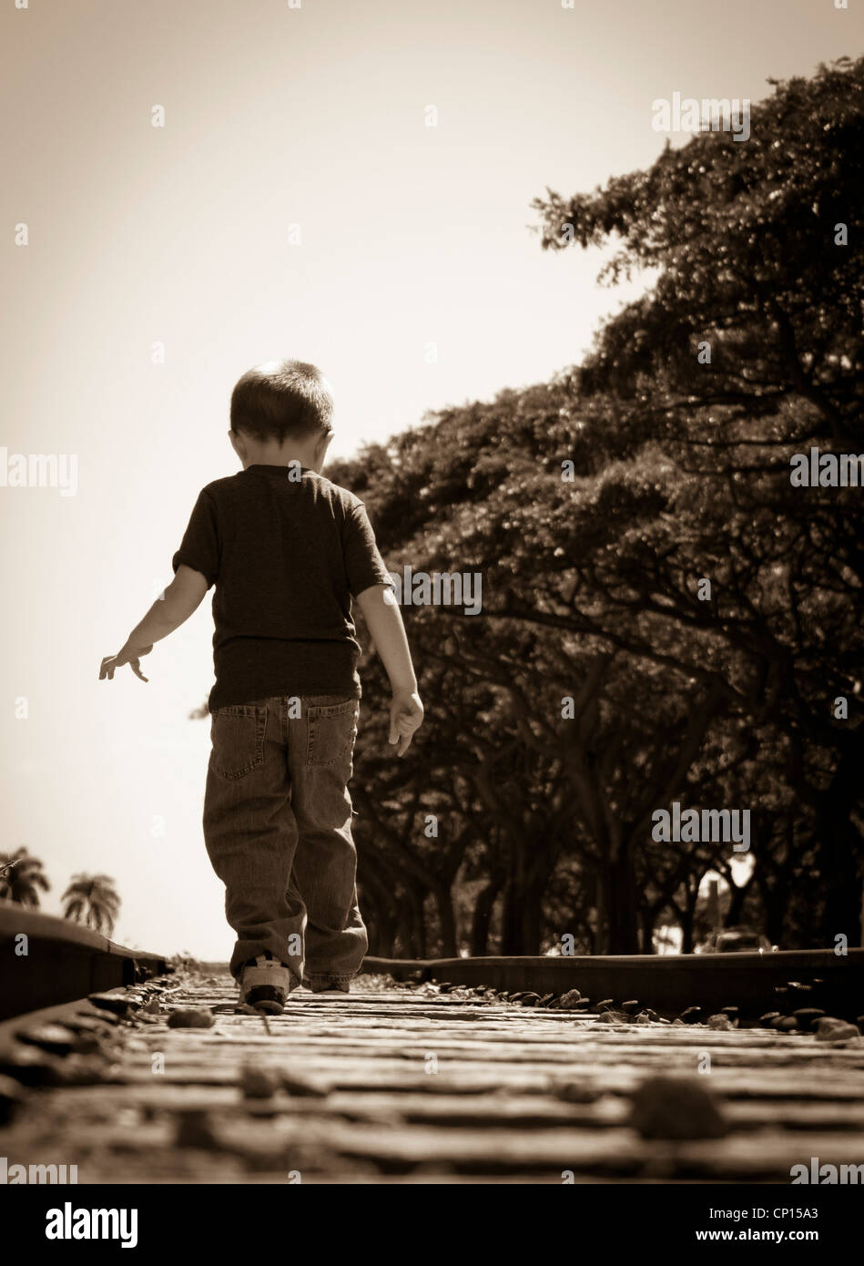 Four year old autistic boy walking away on train tracks Stock Photo - Alamy