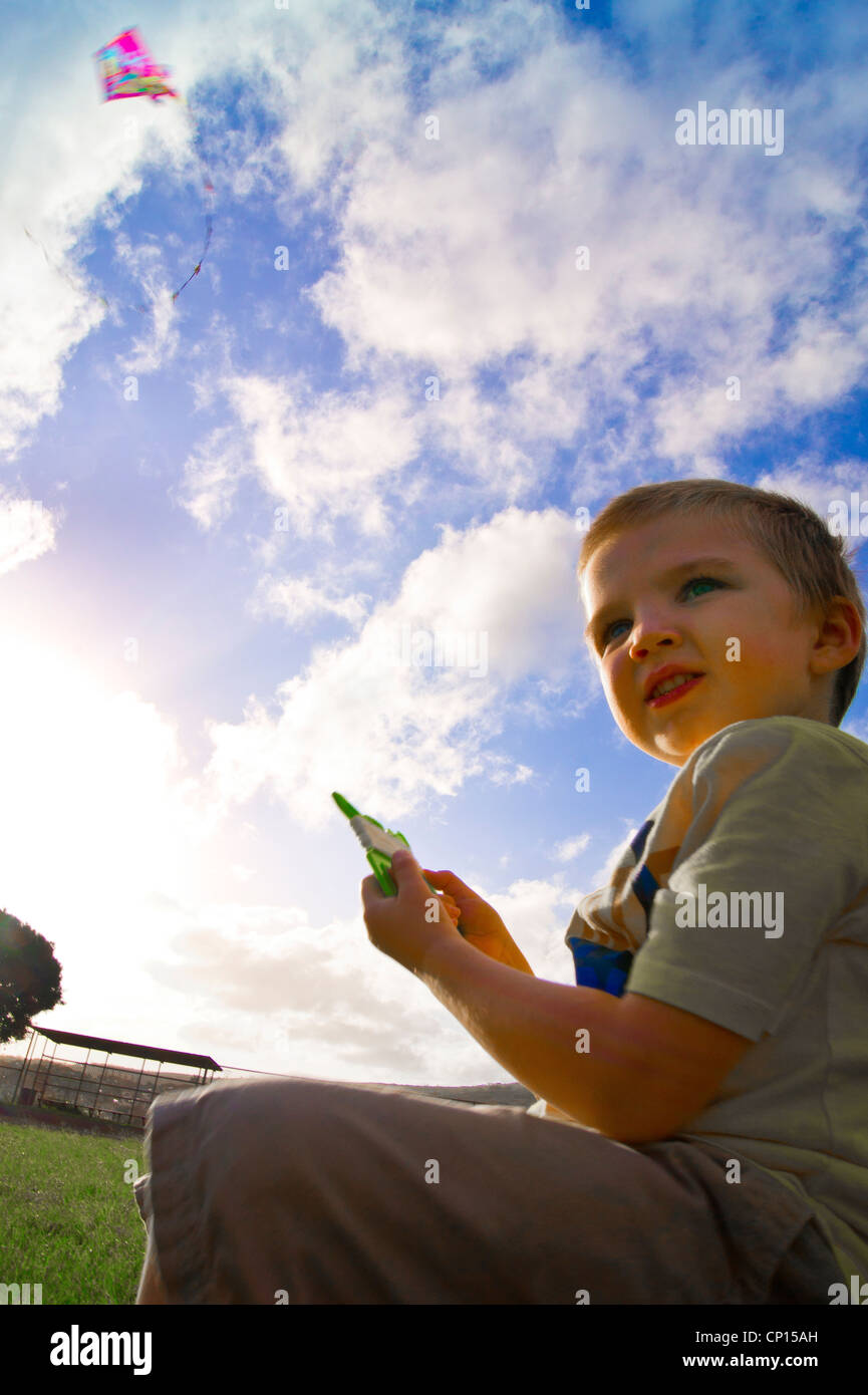 A youg boy's with autism attention has drifted away from his kite ...