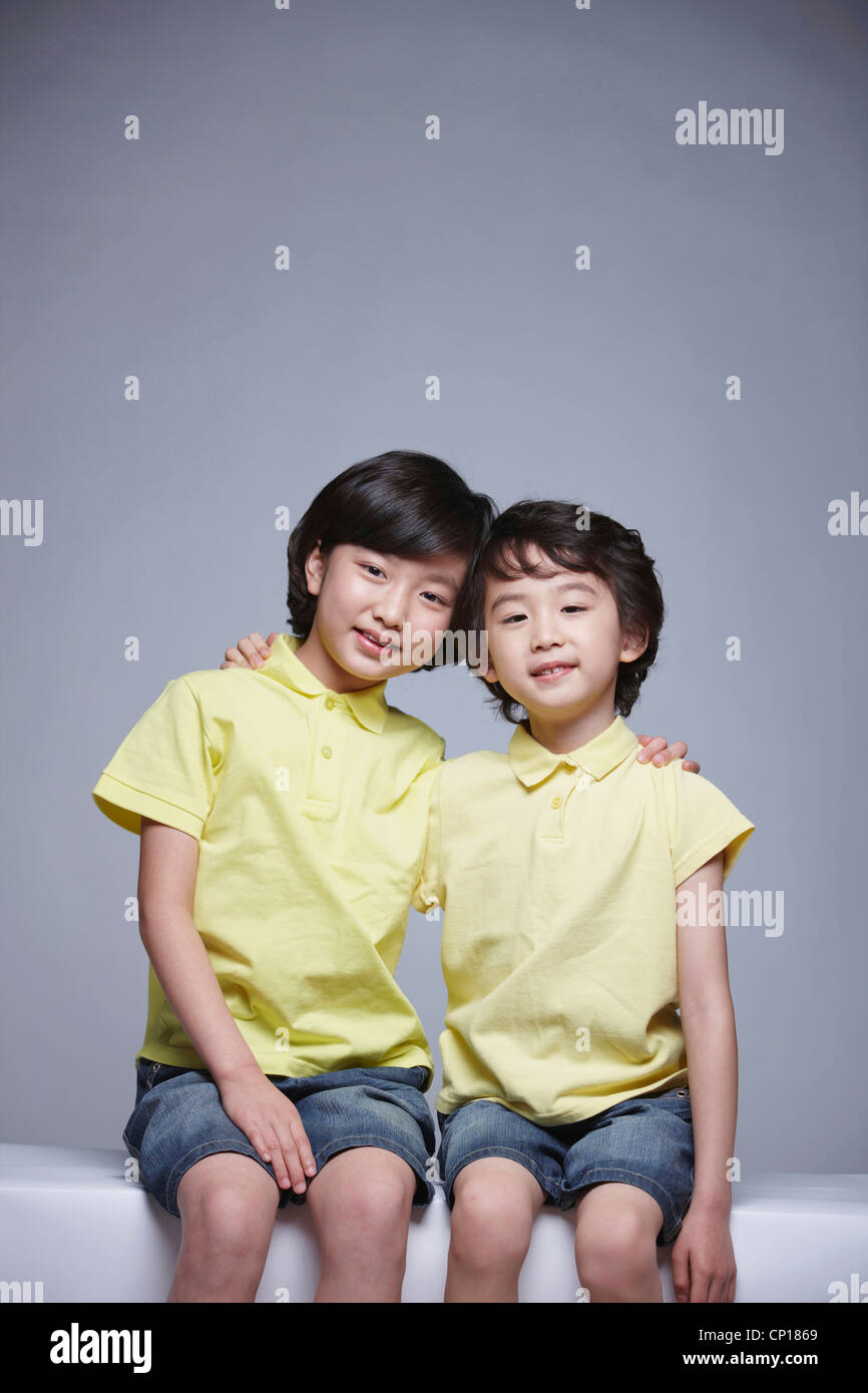 A boy and girl putting arms around each other Stock Photo - Alamy
