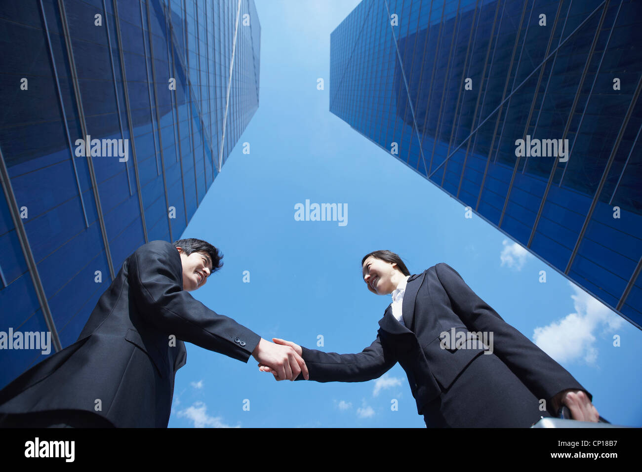Businessmen shaking hands around the buildings Stock Photo - Alamy
