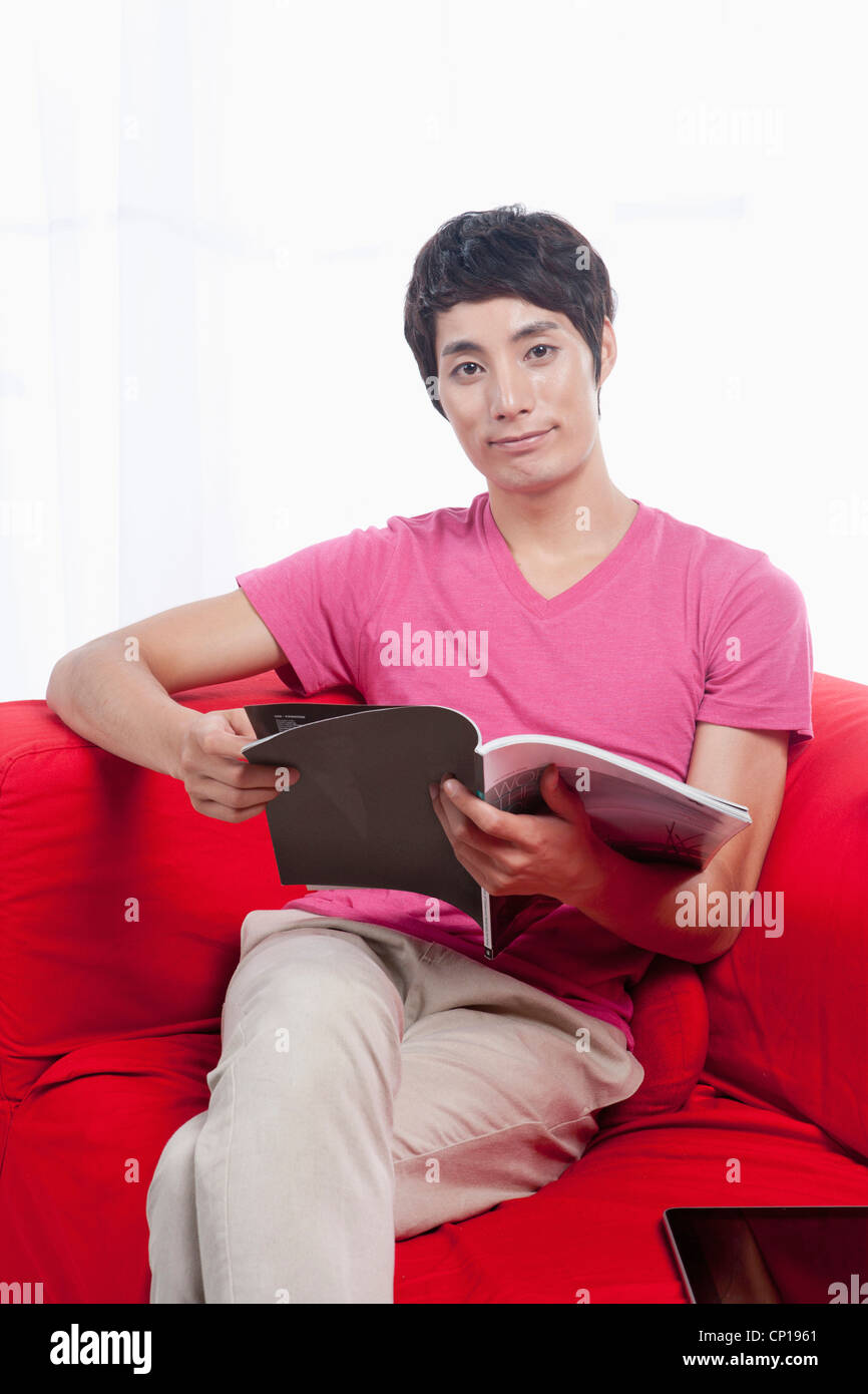 A man reading a magazine on the couch Stock Photo - Alamy