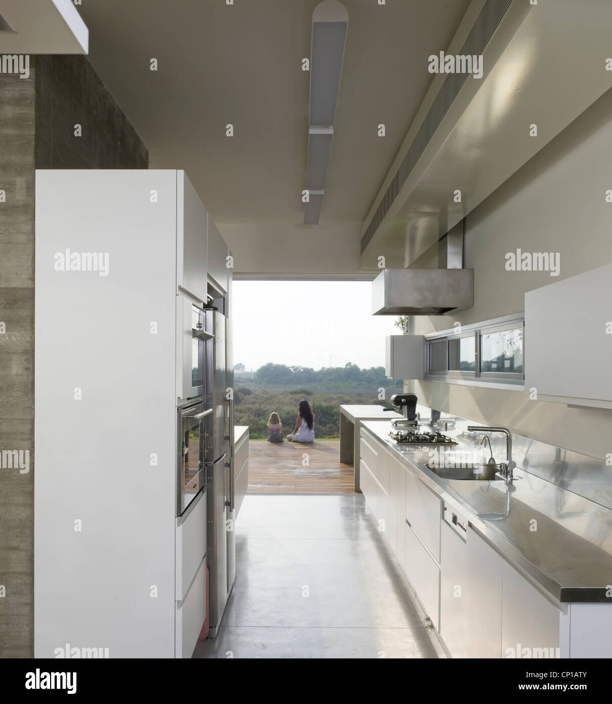 Two children sit on kitchen terrace of house designed by Weinstein ...