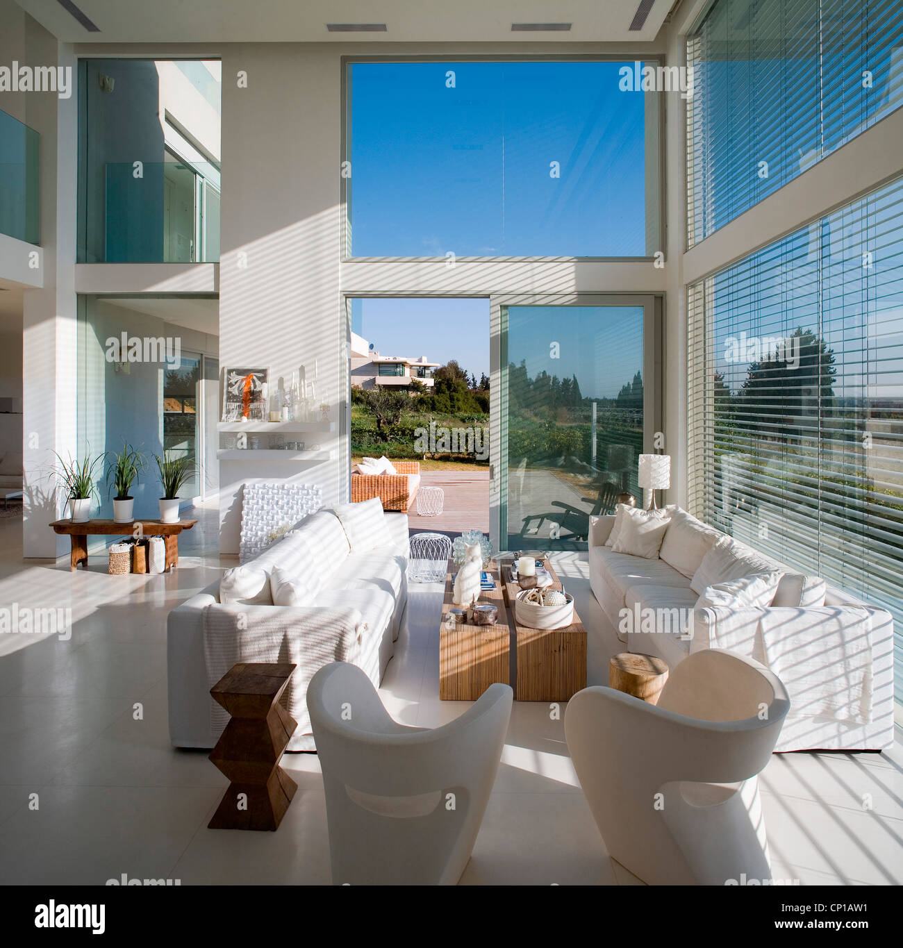 Double height living room with white sofa and chairs in Rishpon in the ...