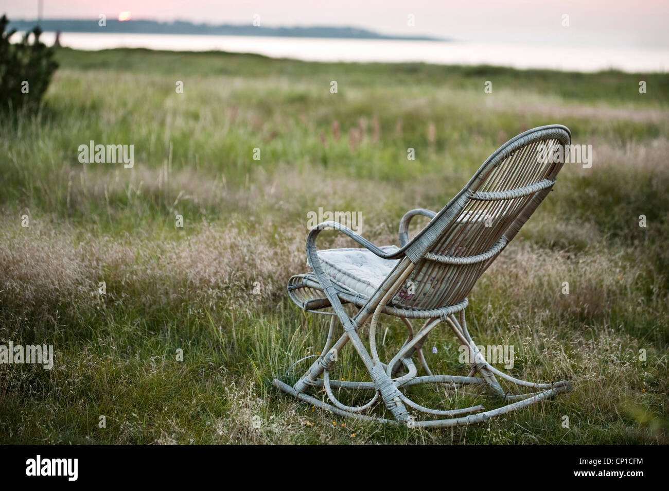 Empty rocking chair facing the sea at dusk Stock Photo - Alamy