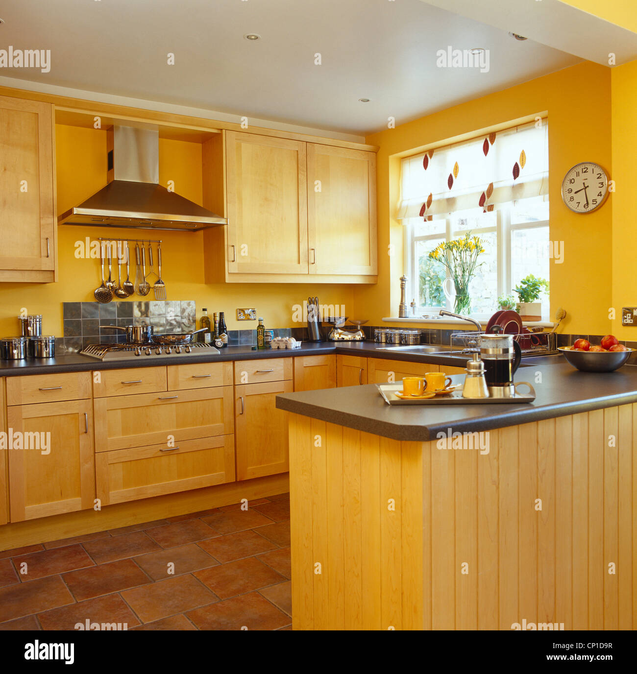 Yellow kitchen with wooden units and tiled floor Stock Photo - Alamy