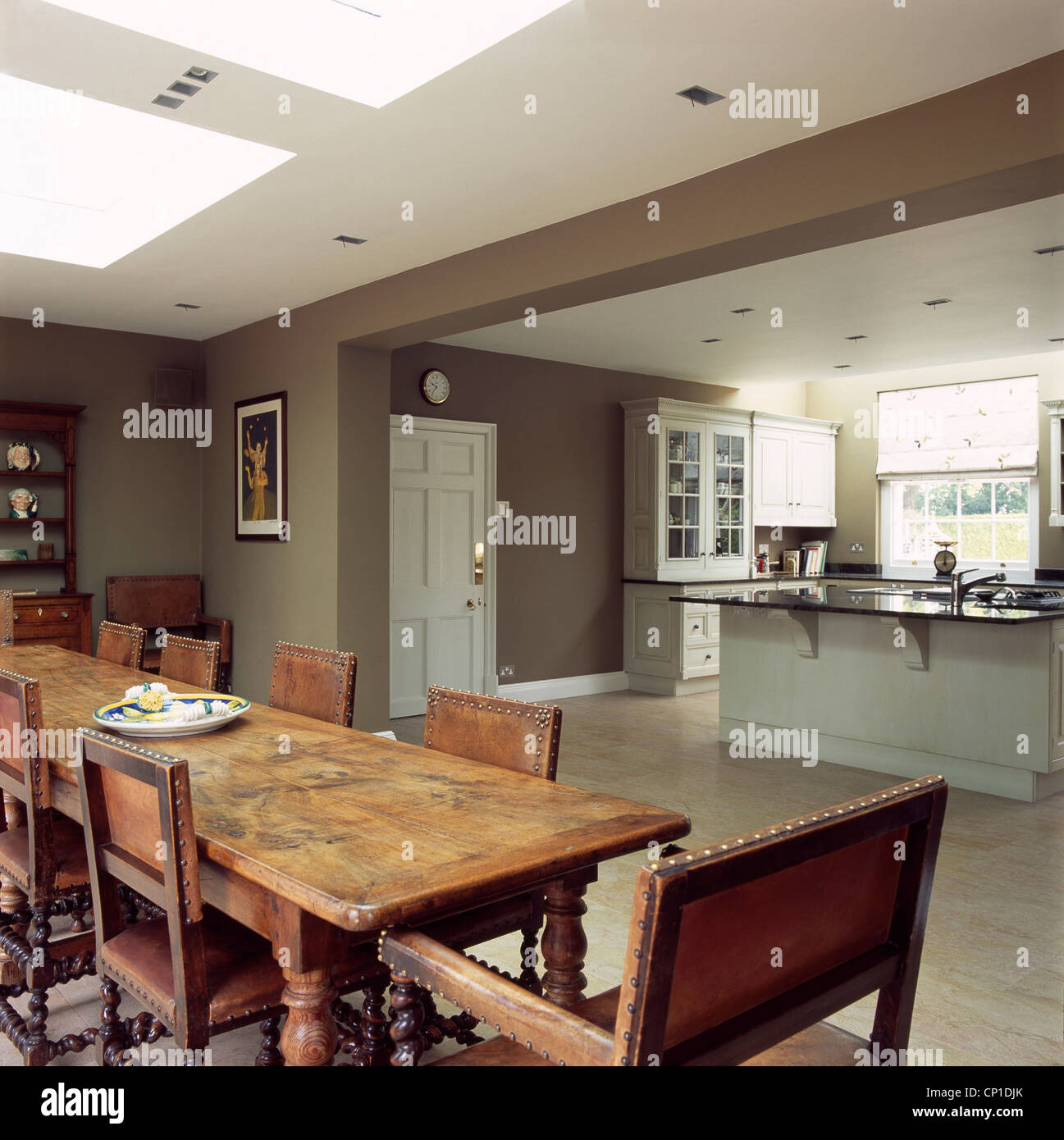 Open plan kitchen and dining room with long table and chairs Stock ...