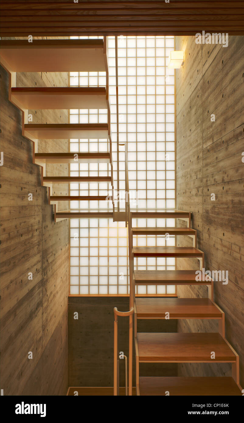 Contemporary wooden staircase in front of tall window Stock Photo - Alamy