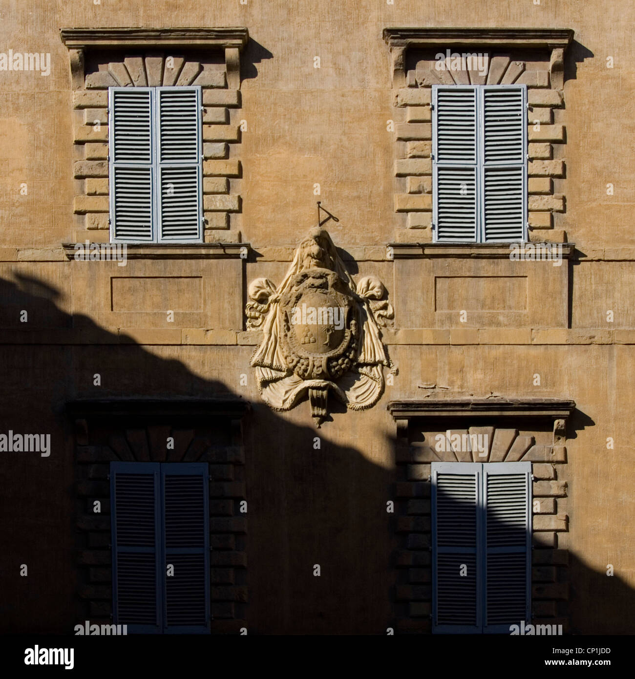 Crest of arms and closed shutters on Siena building exterior, Italy ...