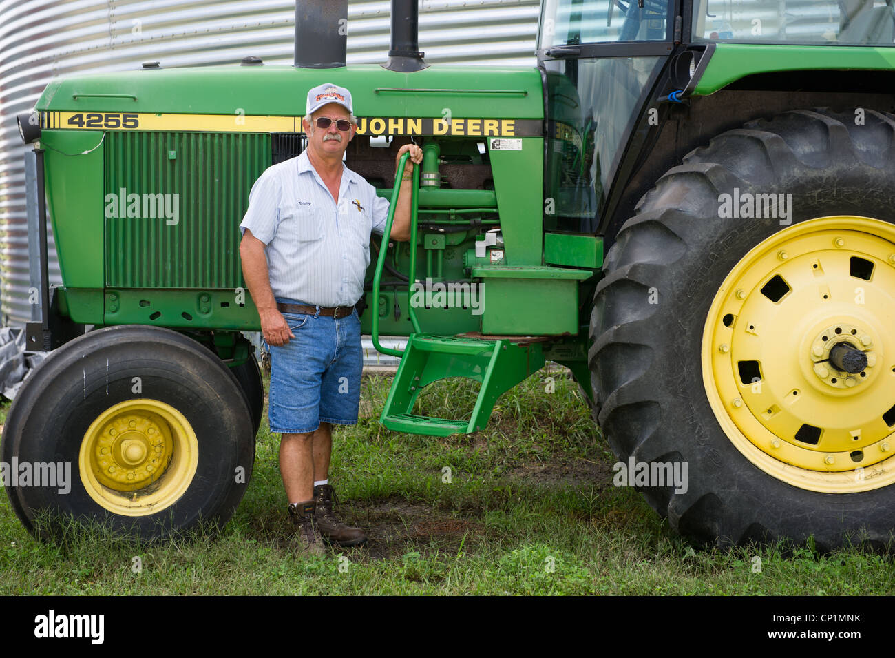 Farmer standing in front of tractor on farm Stock Photo - Alamy