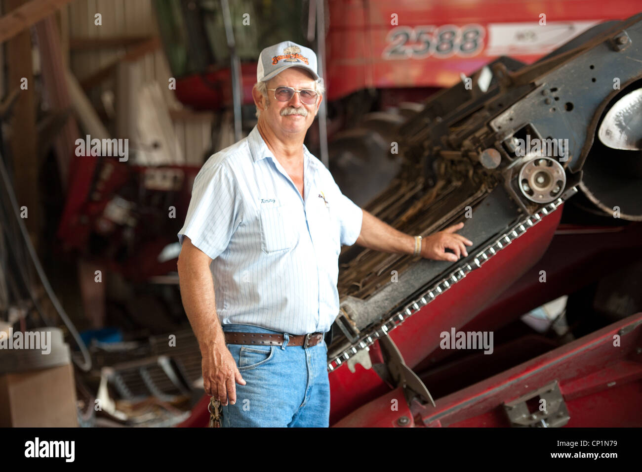 Farmer standing in front of tractor and grain operation on farm Stock ...