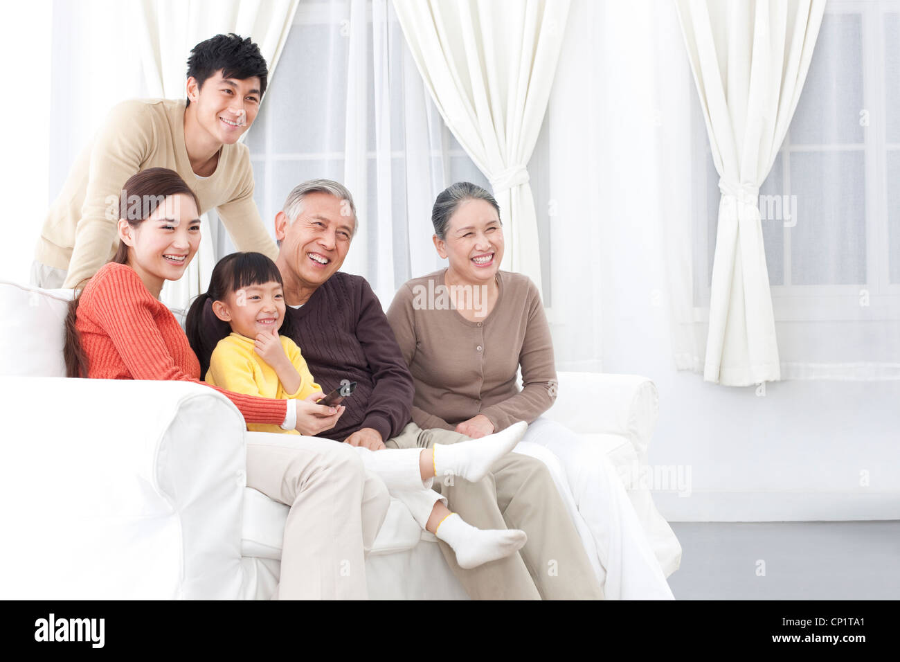 Family watching TV together Stock Photo - Alamy