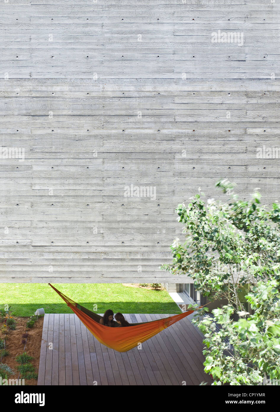 Two people in hammock in walled garden of Hofit House, Israel ...