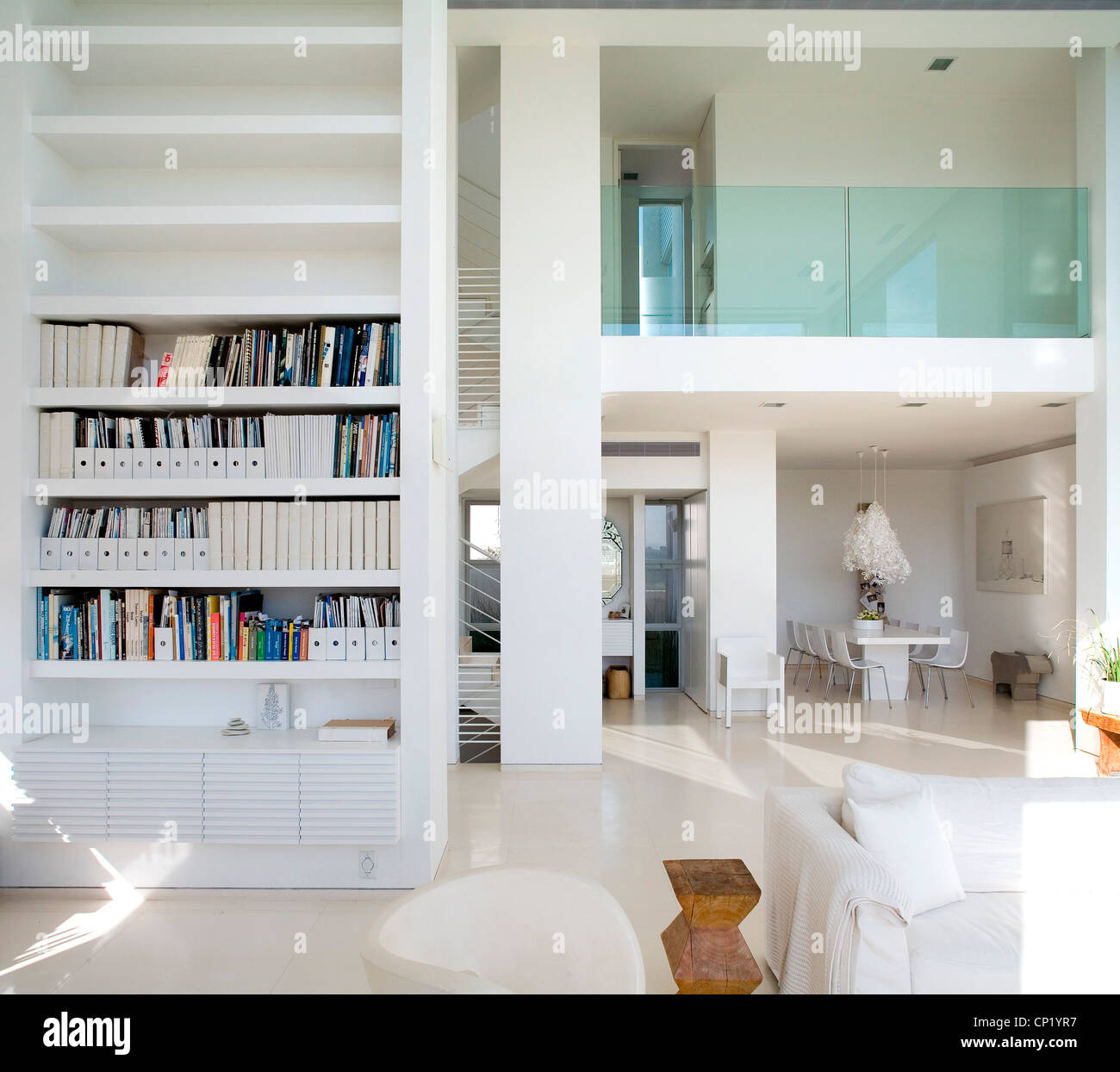 Storage shelving in open plan living area in all-white interior ...