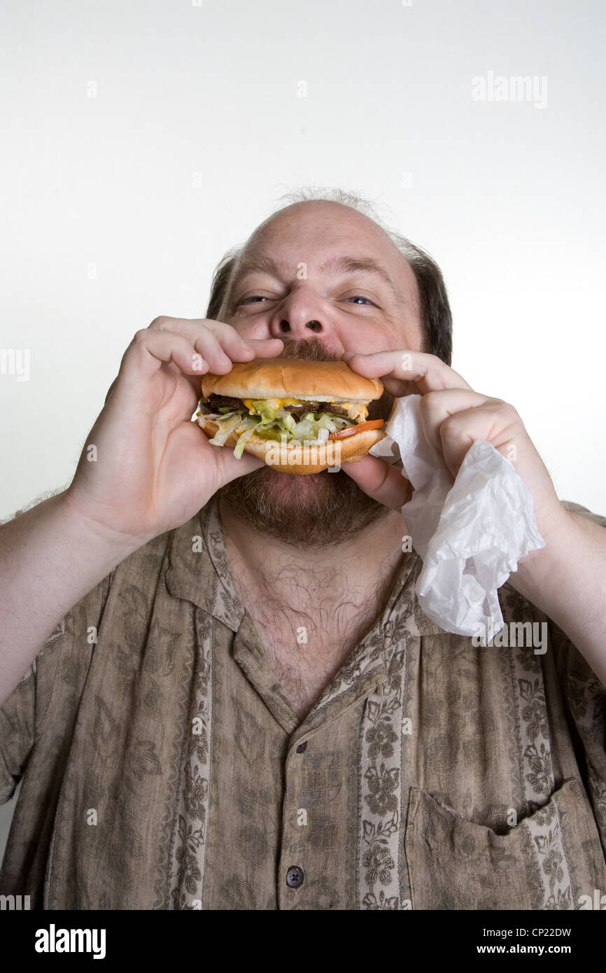 Overweight man in mid forties eating fast food Stock Photo - Alamy