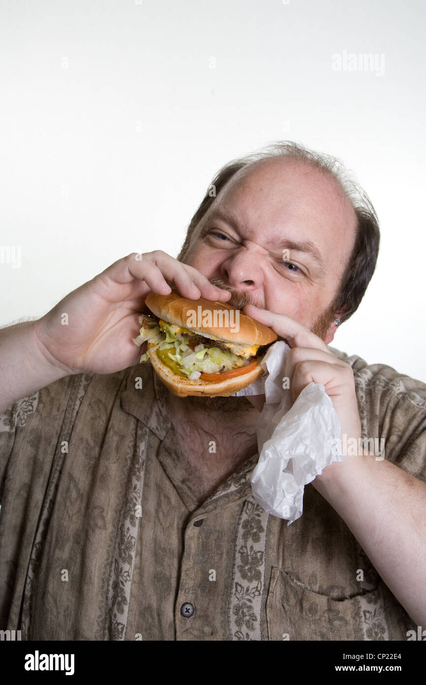 Overweight man in mid forties eating fast food Stock Photo - Alamy