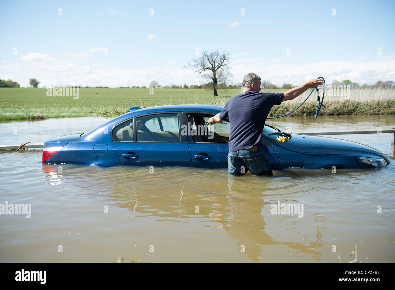 A BMW car is trapped in floodwater in a ford that has become too deep ...