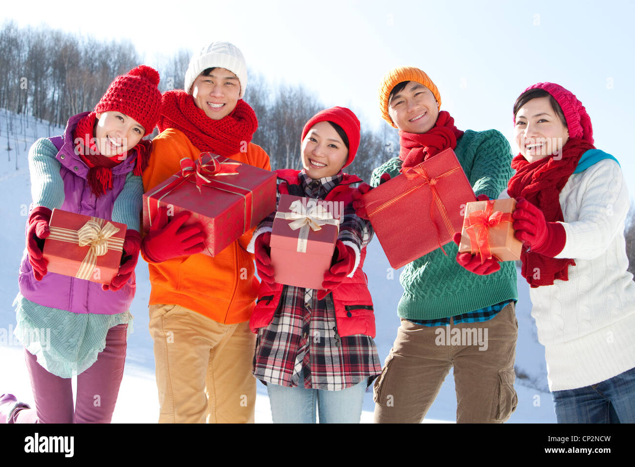 Happy young people holding gift boxes Stock Photo - Alamy