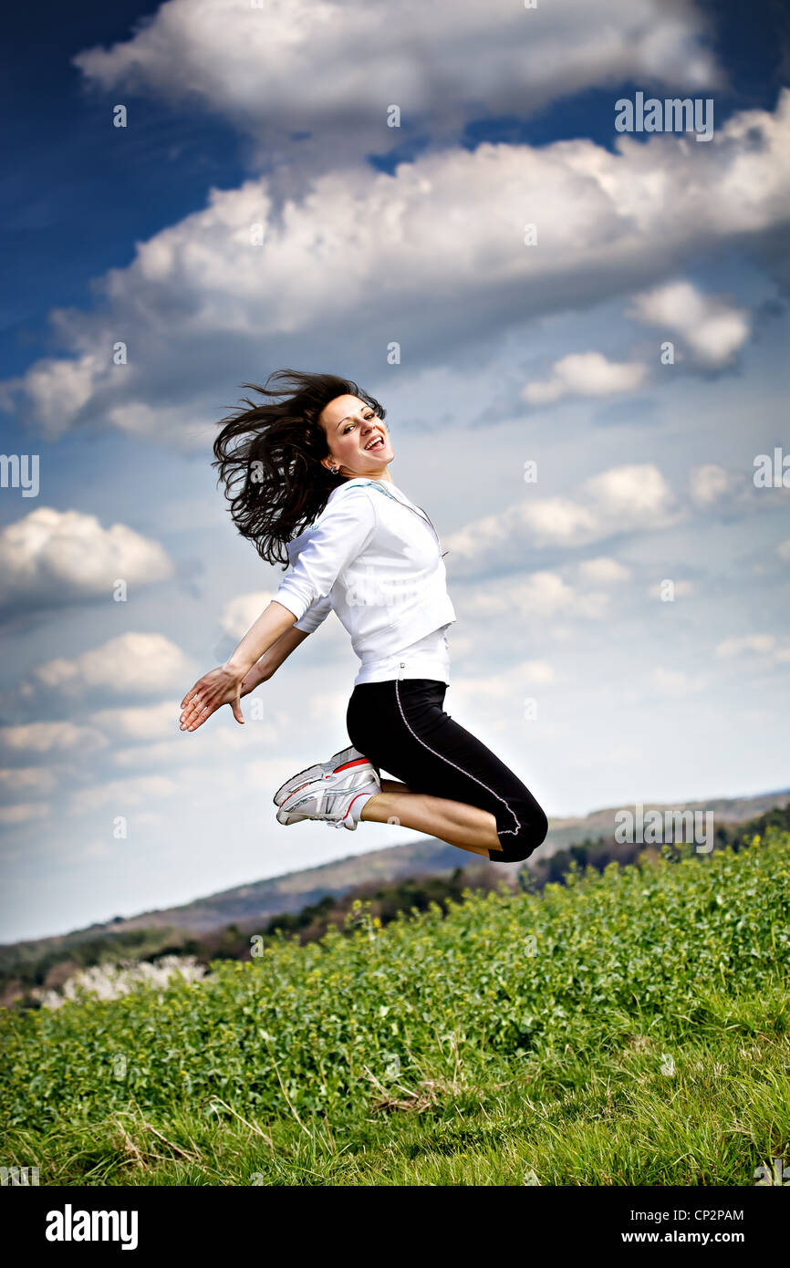 a young jumping woman in front of rural landscape Stock Photo - Alamy