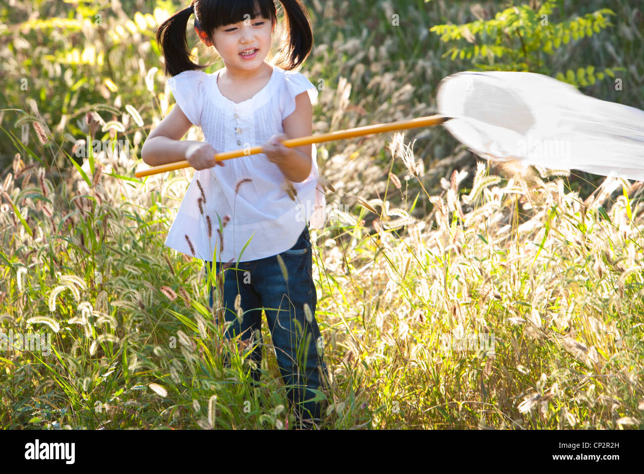 Young Chinese girl playing in a field Stock Photo - Alamy