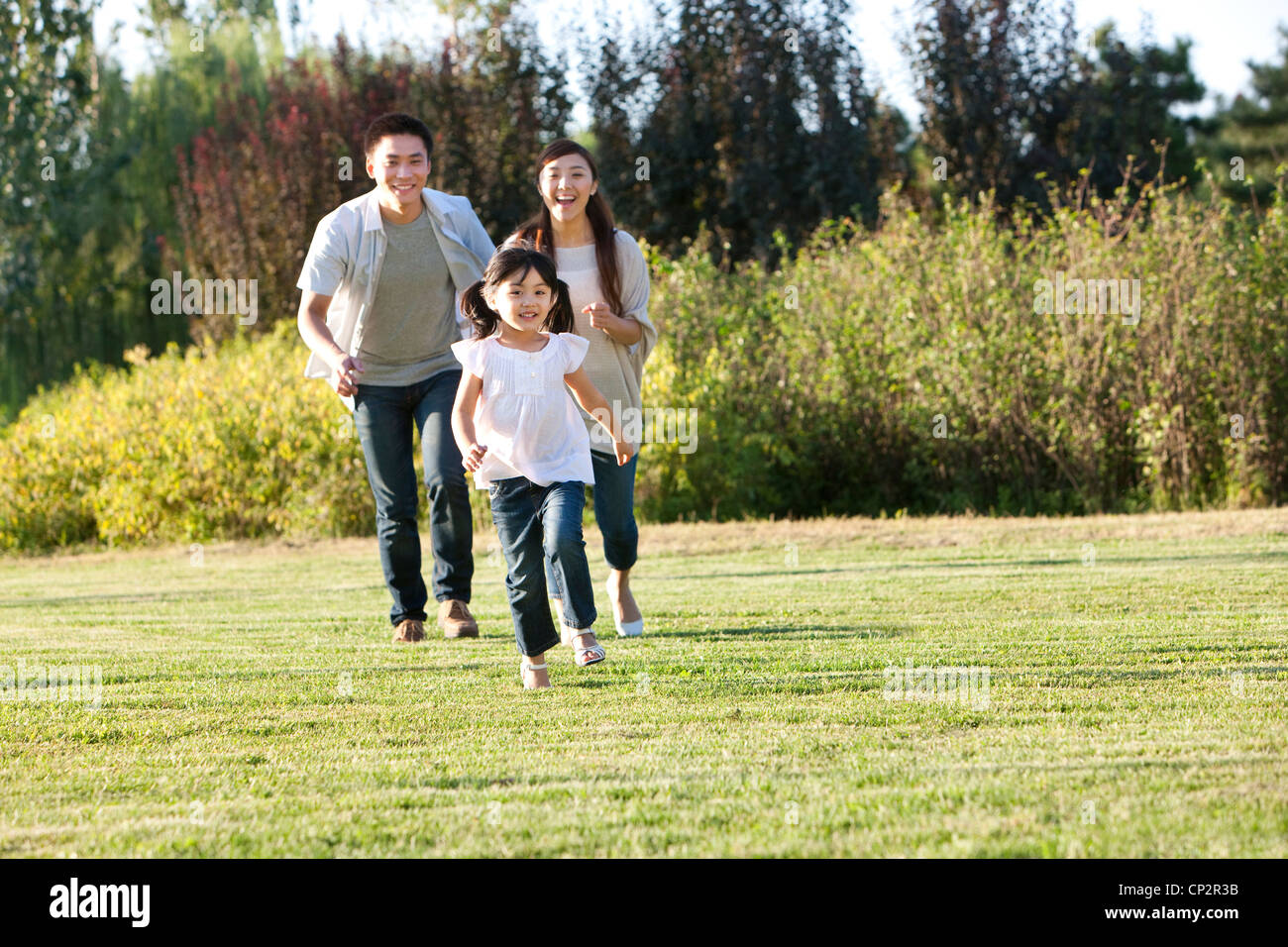 Young Chinese family running in a field Stock Photo - Alamy