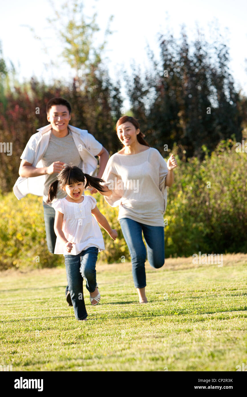 Young Chinese family running in a field Stock Photo - Alamy