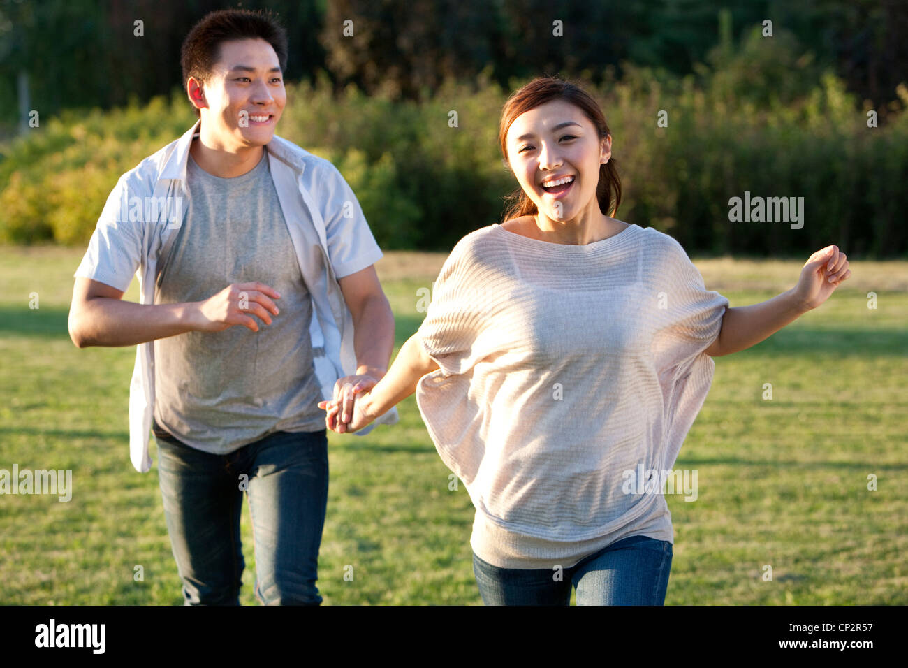 Young Chinese couple running in a park Stock Photo - Alamy