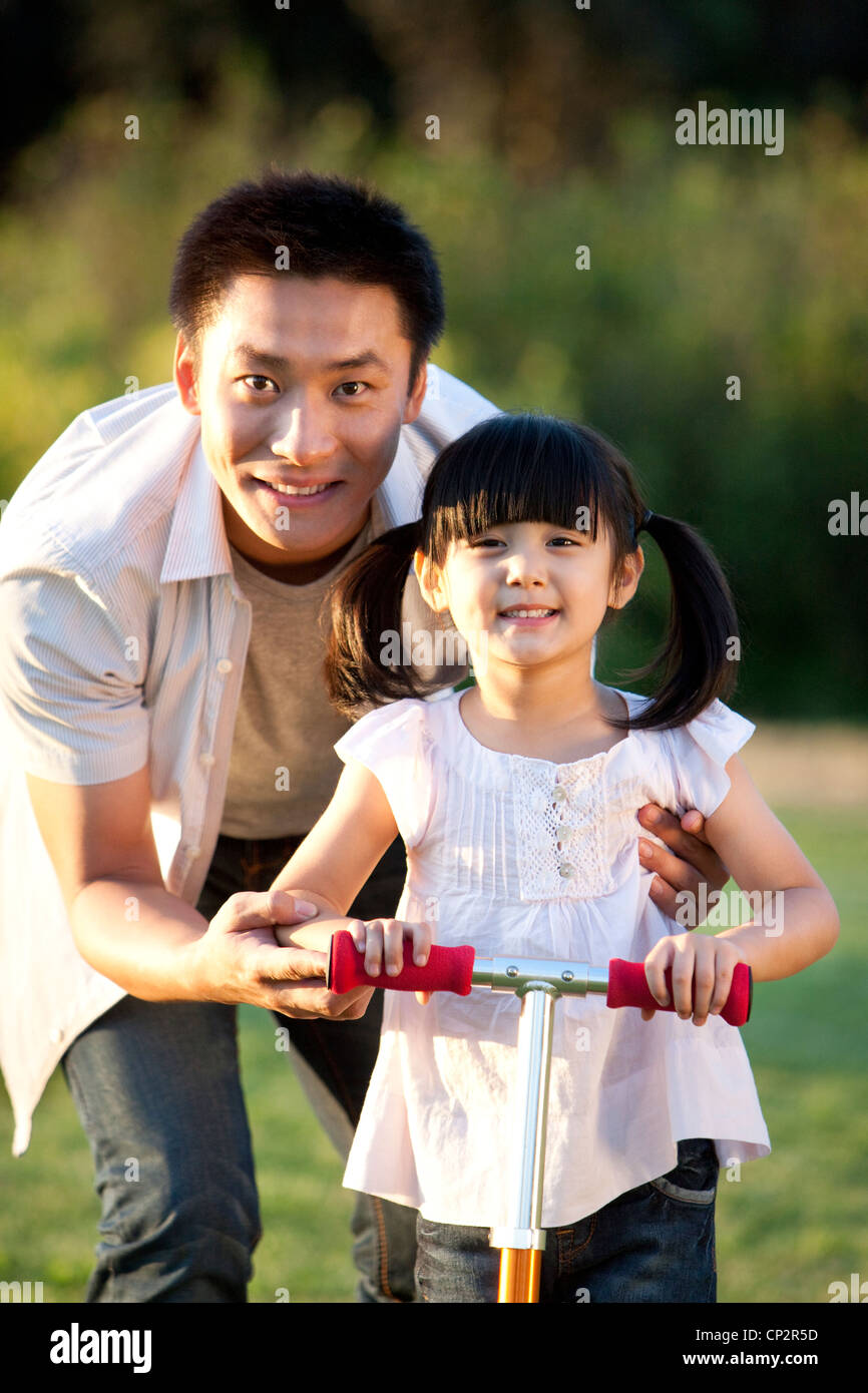 Young Chinese father with dauther and scooter Stock Photo - Alamy